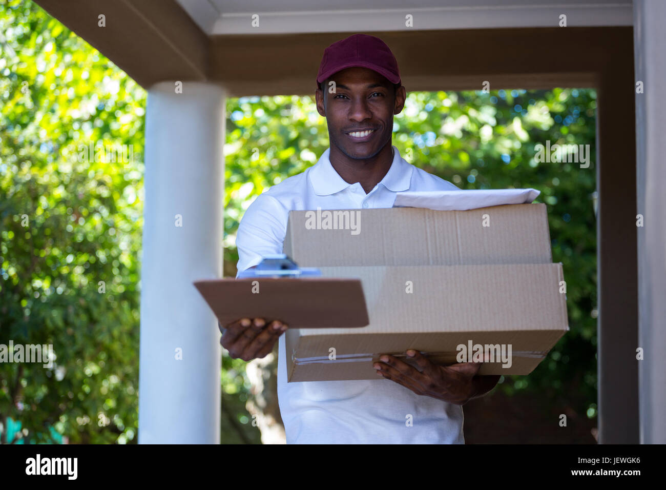 Happy delivery man with parcel Stock Photo - Alamy