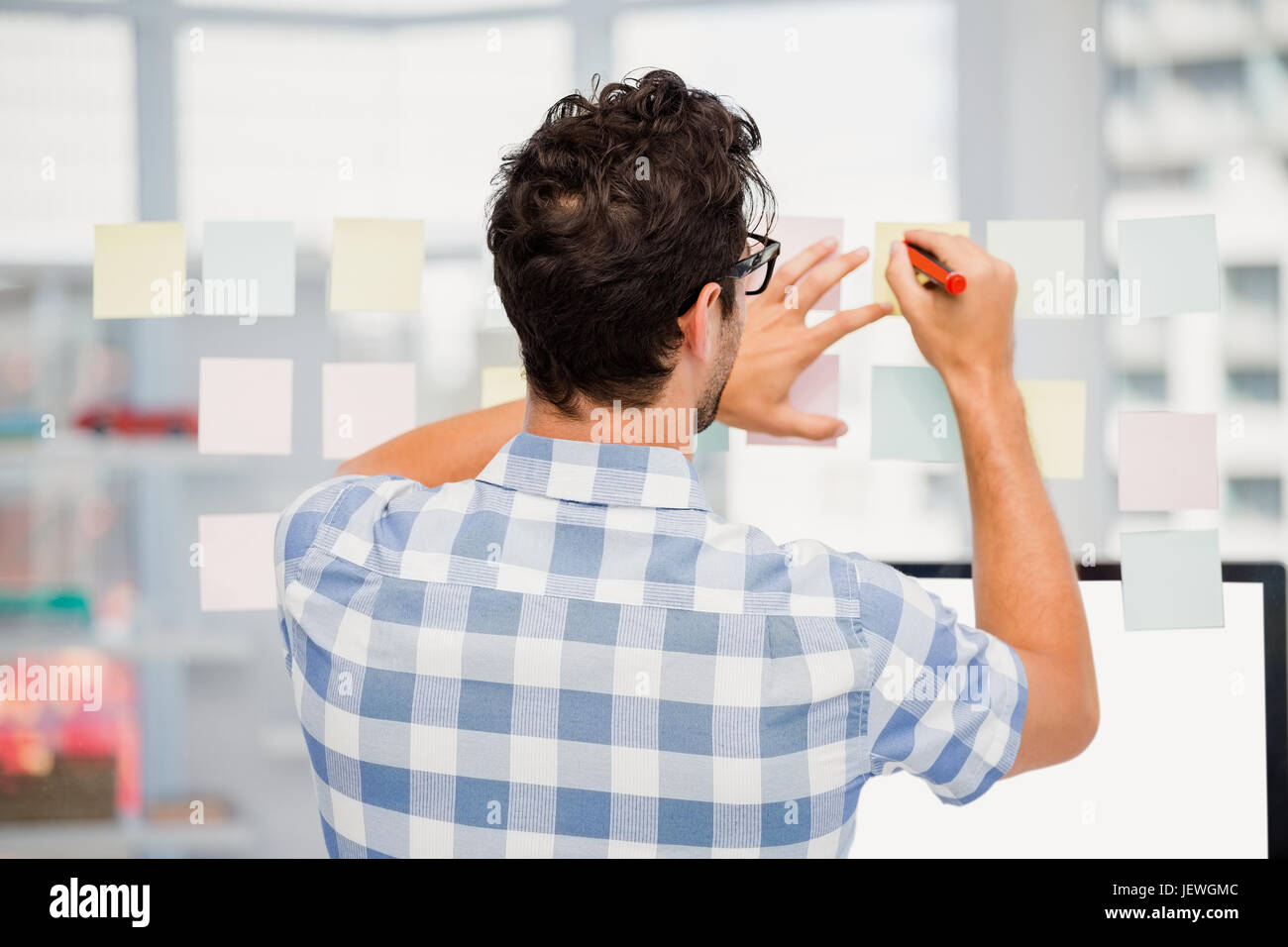 Rear view of man writing on sticky notes Stock Photo - Alamy