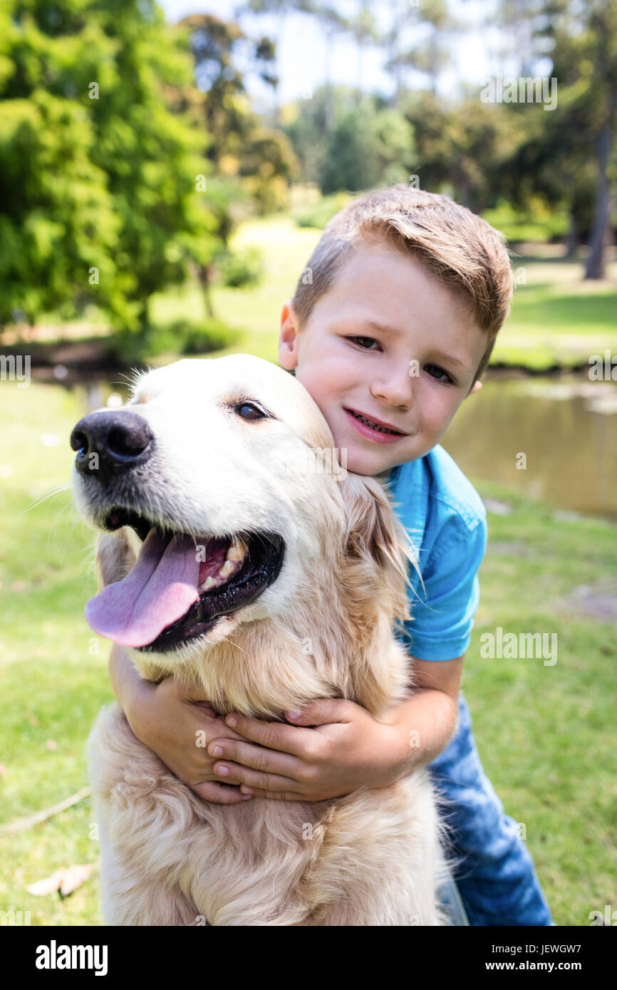 Smiling boy with his pet dog in the park Stock Photo - Alamy