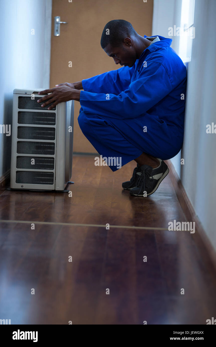 Handyman testing air conditioner Stock Photo - Alamy