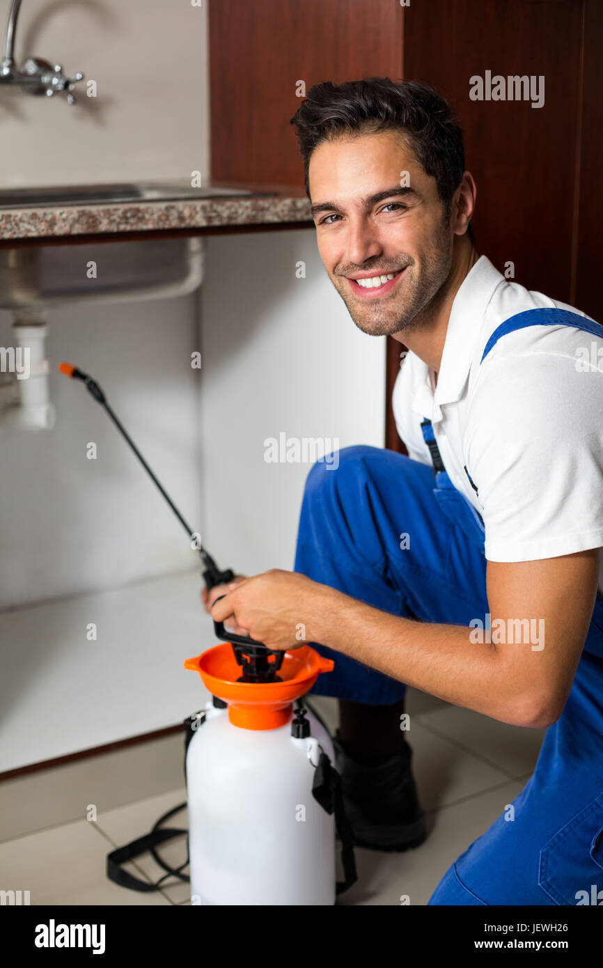 Portrait of cheerful man spraying insecticide Stock Photo - Alamy