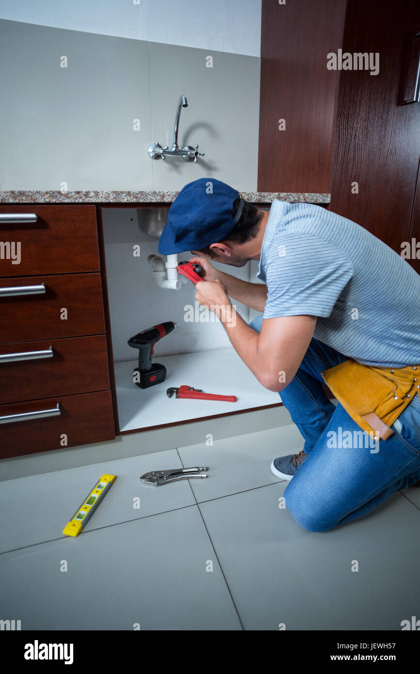Full length of man using pipe wrench Stock Photo - Alamy