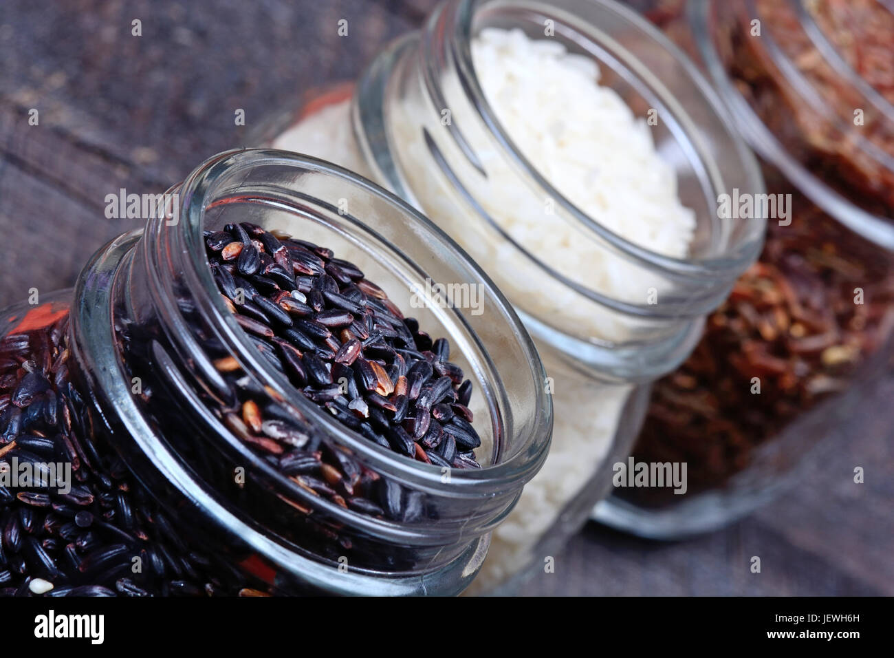 Different types of rice in a jars on wooden table Stock Photo - Alamy