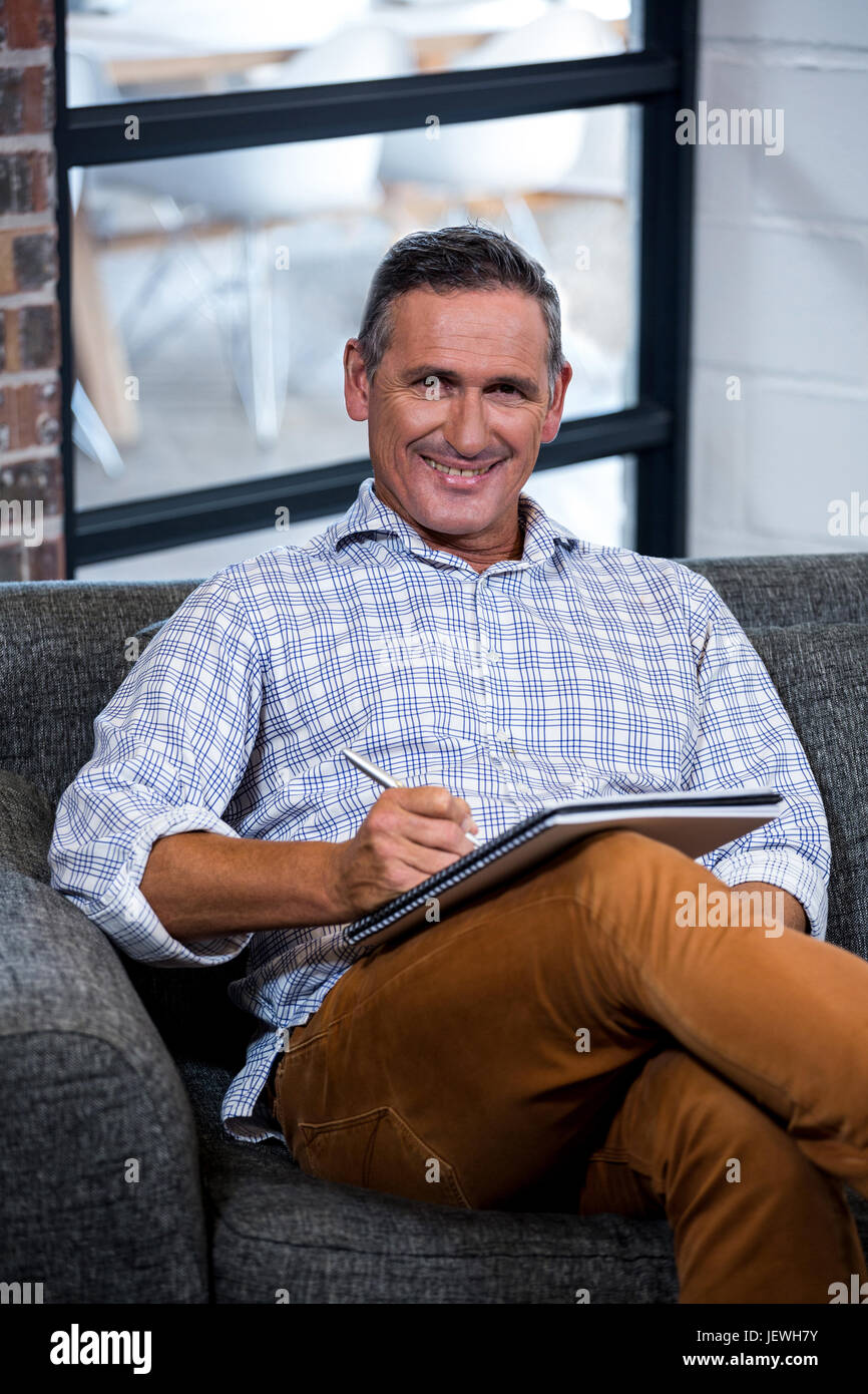 Man writing note on diary Stock Photo - Alamy