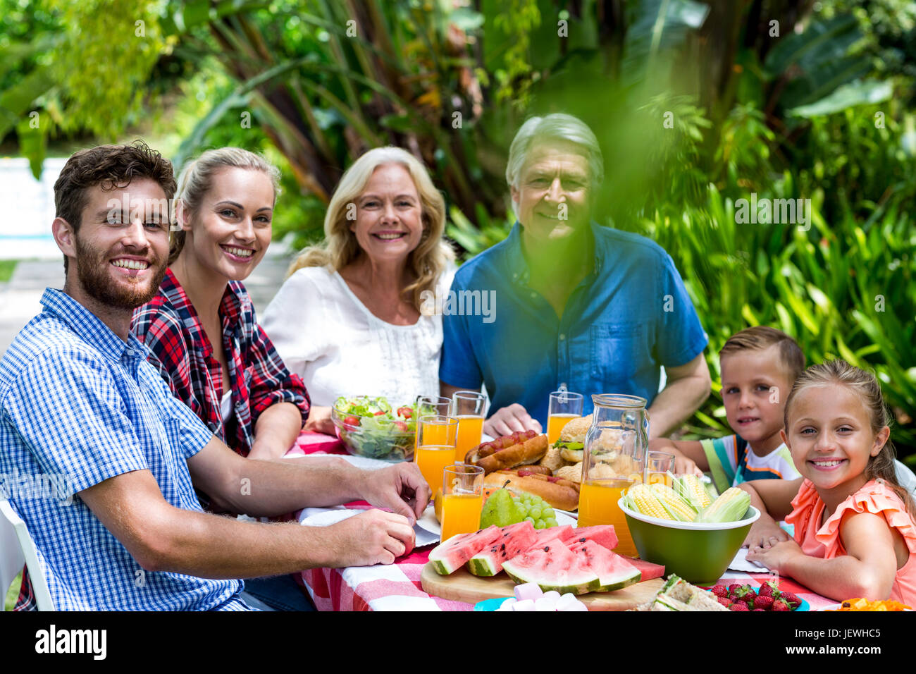 Happy family having lunch in yard Stock Photo - Alamy