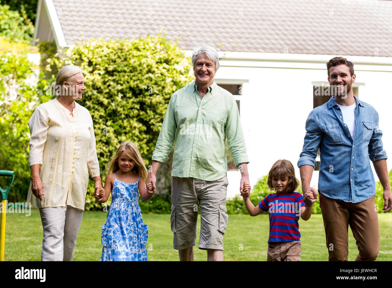 Happy family walking outside house at yard Stock Photo - Alamy