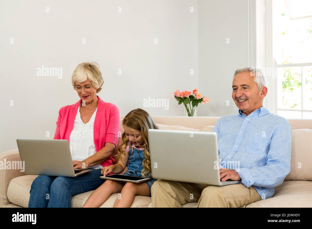 Happy grandparents and girl using technology Stock Photo - Alamy