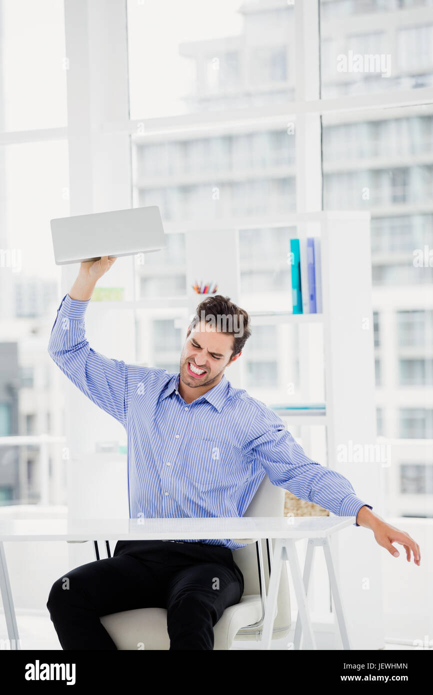 Frustrated businessman throwing laptop Stock Photo - Alamy