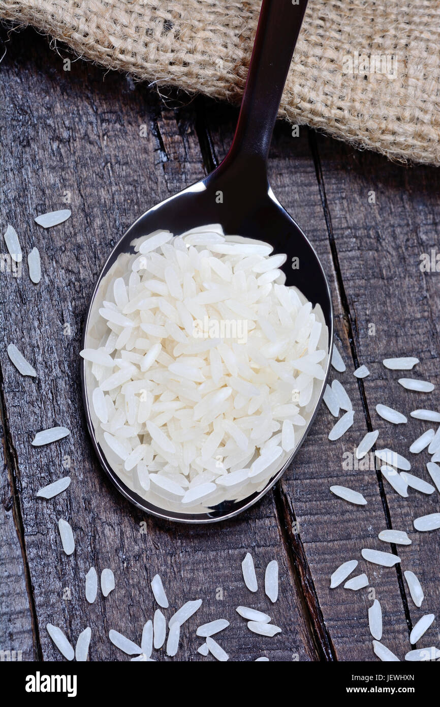 White rice in a silver spoon on wooden table Stock Photo - Alamy
