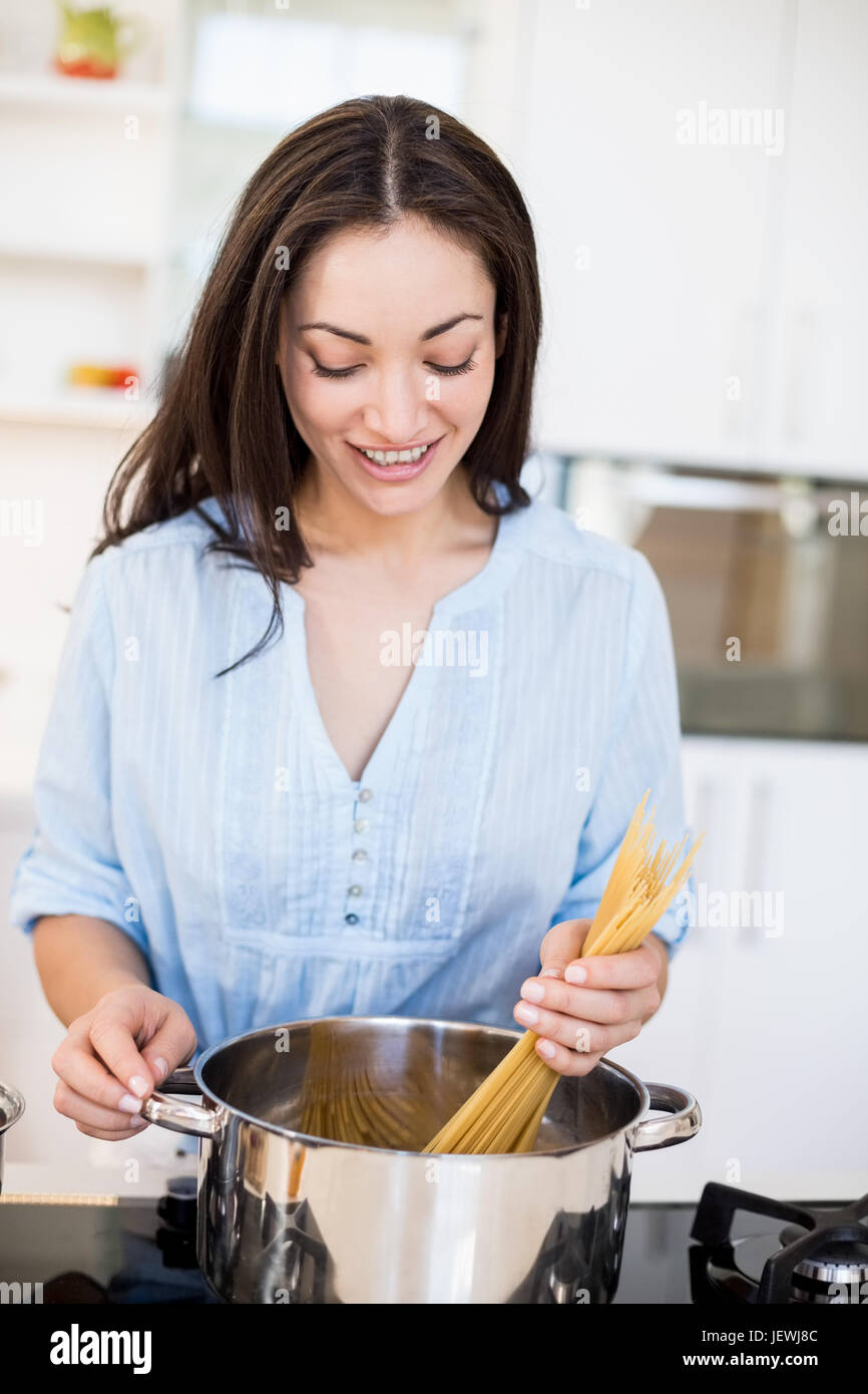Woman preparing spaghetti noodles in kitchen Stock Photo - Alamy