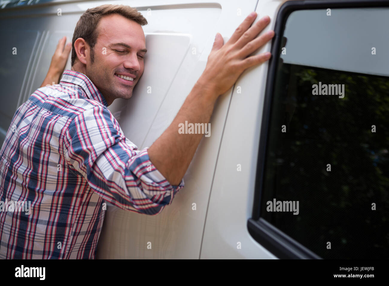 Young man hugging his car Stock Photo - Alamy