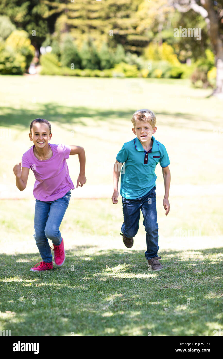 Siblings with running in park Stock Photo - Alamy