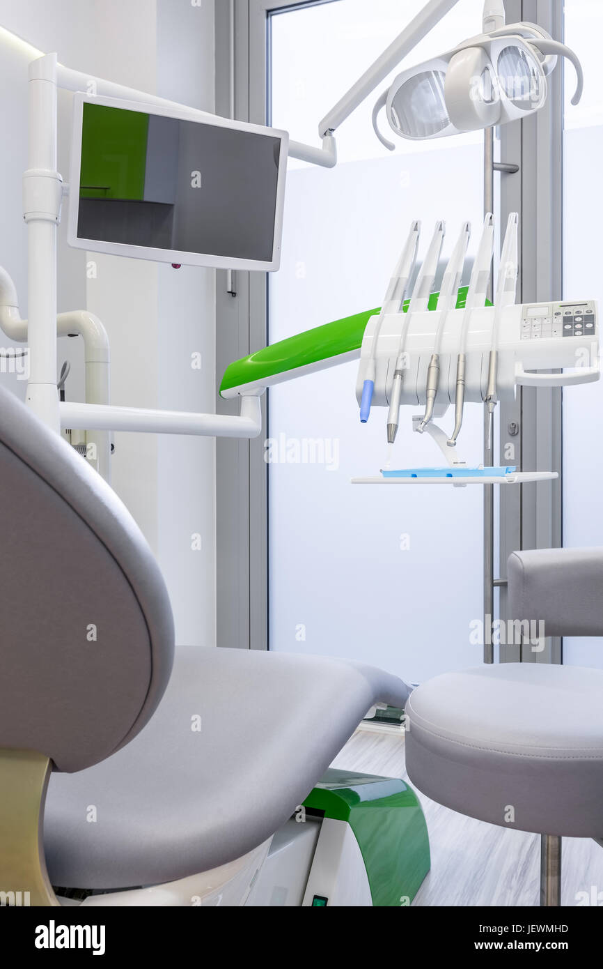 Dental room with gray chair, computer screen, lamp and drills Stock ...
