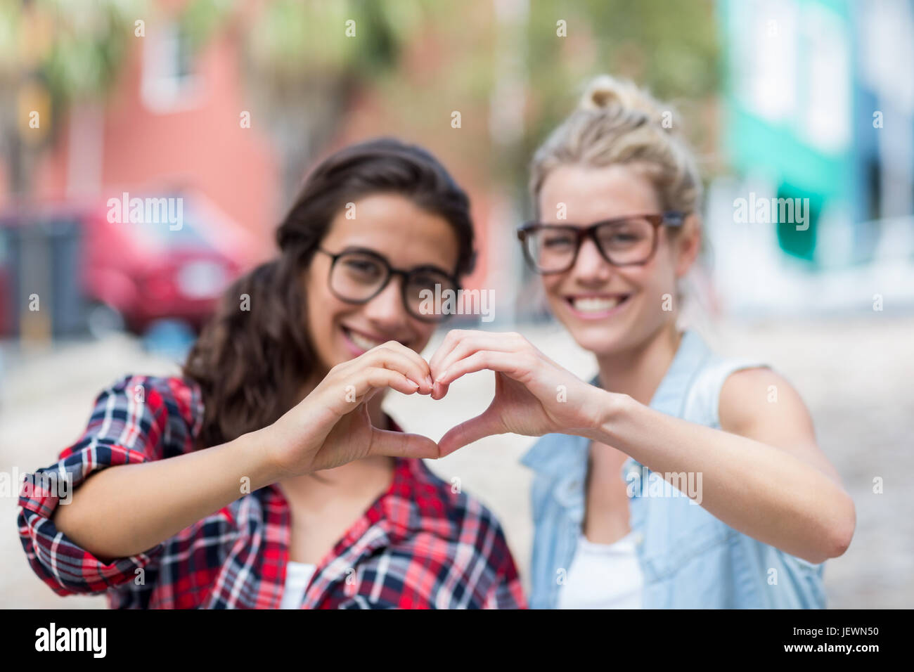 Friends making heart shape with hands Stock Photo - Alamy