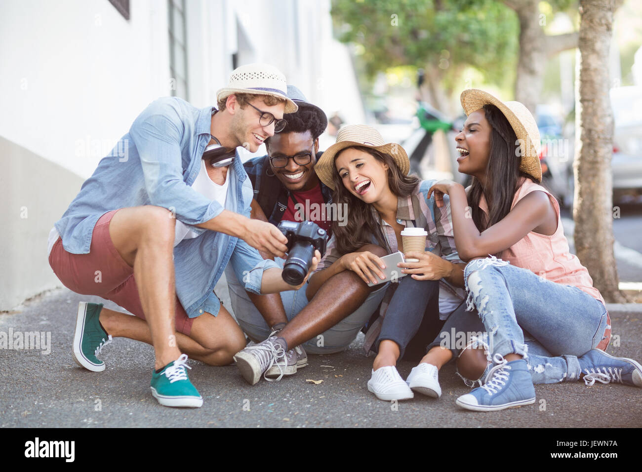 Man showing photos in camera to his friends Stock Photo - Alamy