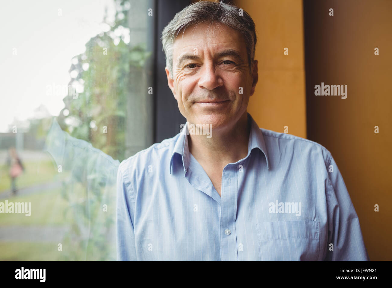 Portrait of professor standing near window Stock Photo - Alamy