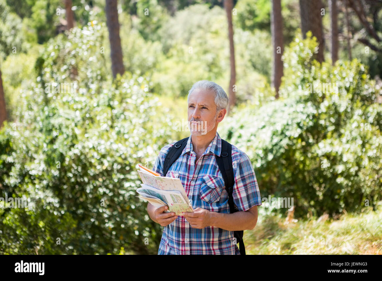 senior man is standing and carrying a map Stock Photo - Alamy