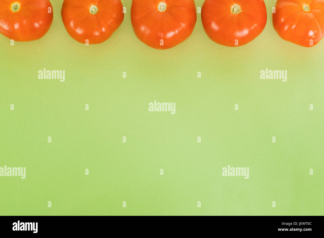 A frame of tomatoes on a pale green background. Kitchen background ...