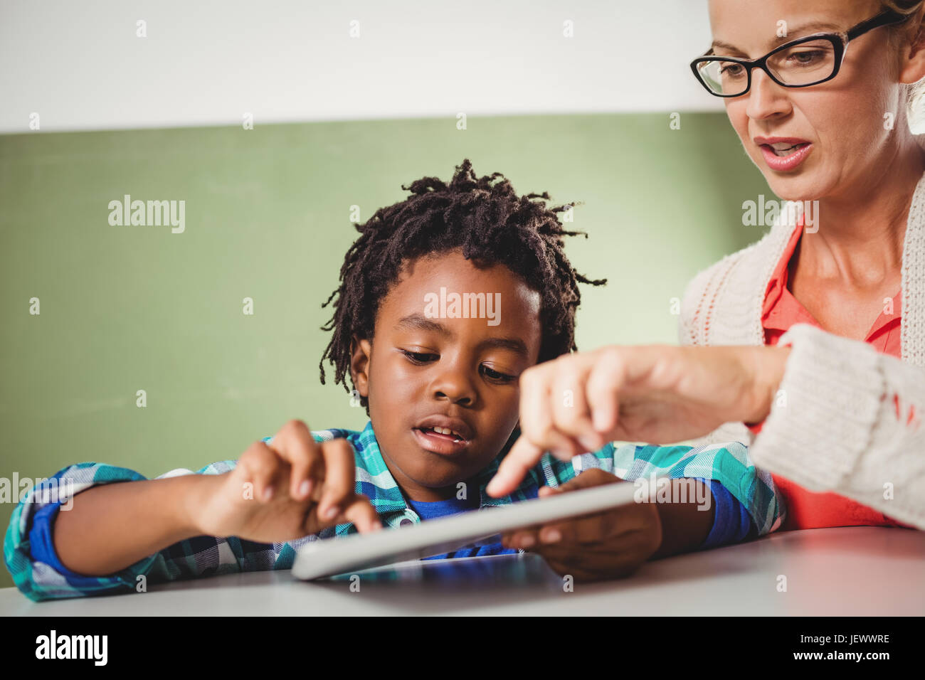 Teacher and pupil using a tablet Stock Photo - Alamy