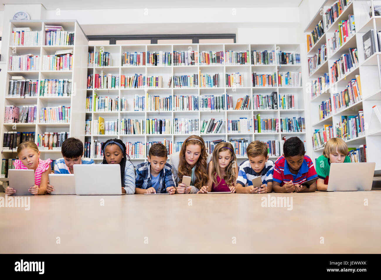 Teacher giving lesson to her students Stock Photo - Alamy