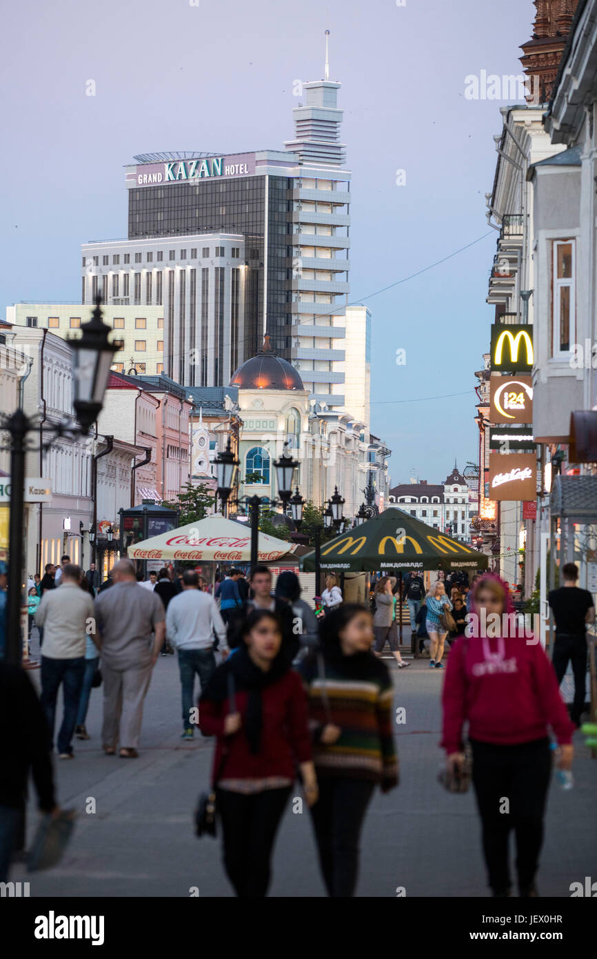 Passers-by walk at sunset along the pedestrian area (ulitsa Baumana) of ...