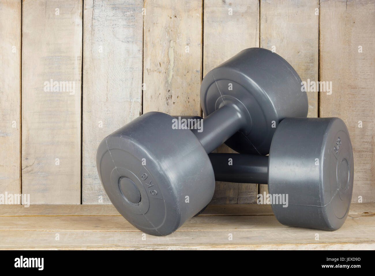 Plastic weights of 5 kgs in a wooden background Stock Photo - Alamy