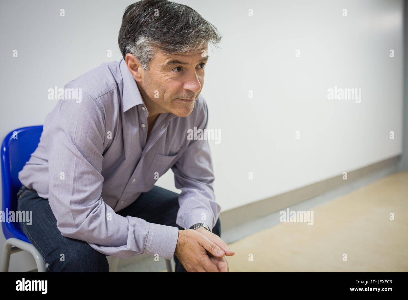 Thoughtful professor sitting on chair Stock Photo - Alamy