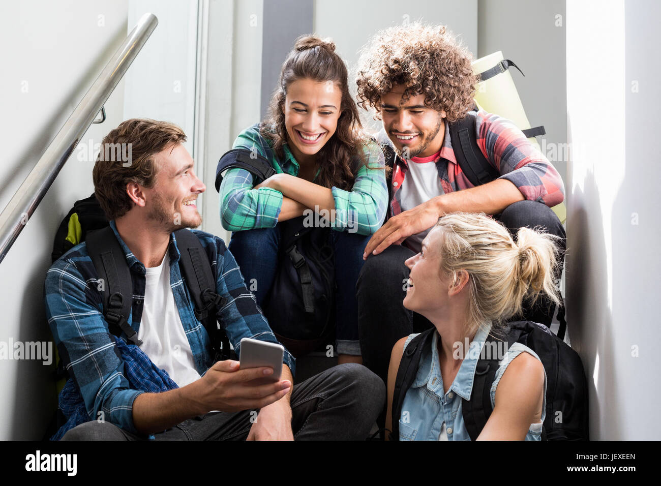 Man showing mobile phone to his friends Stock Photo - Alamy