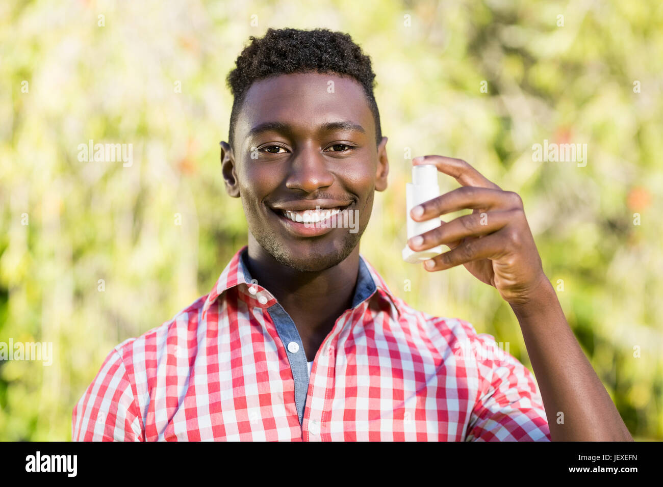 Happy man using an object Stock Photo - Alamy