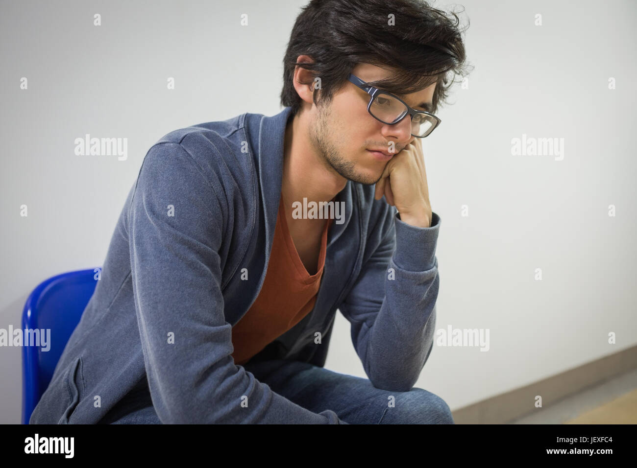 Thoughtful student sitting on chair Stock Photo - Alamy