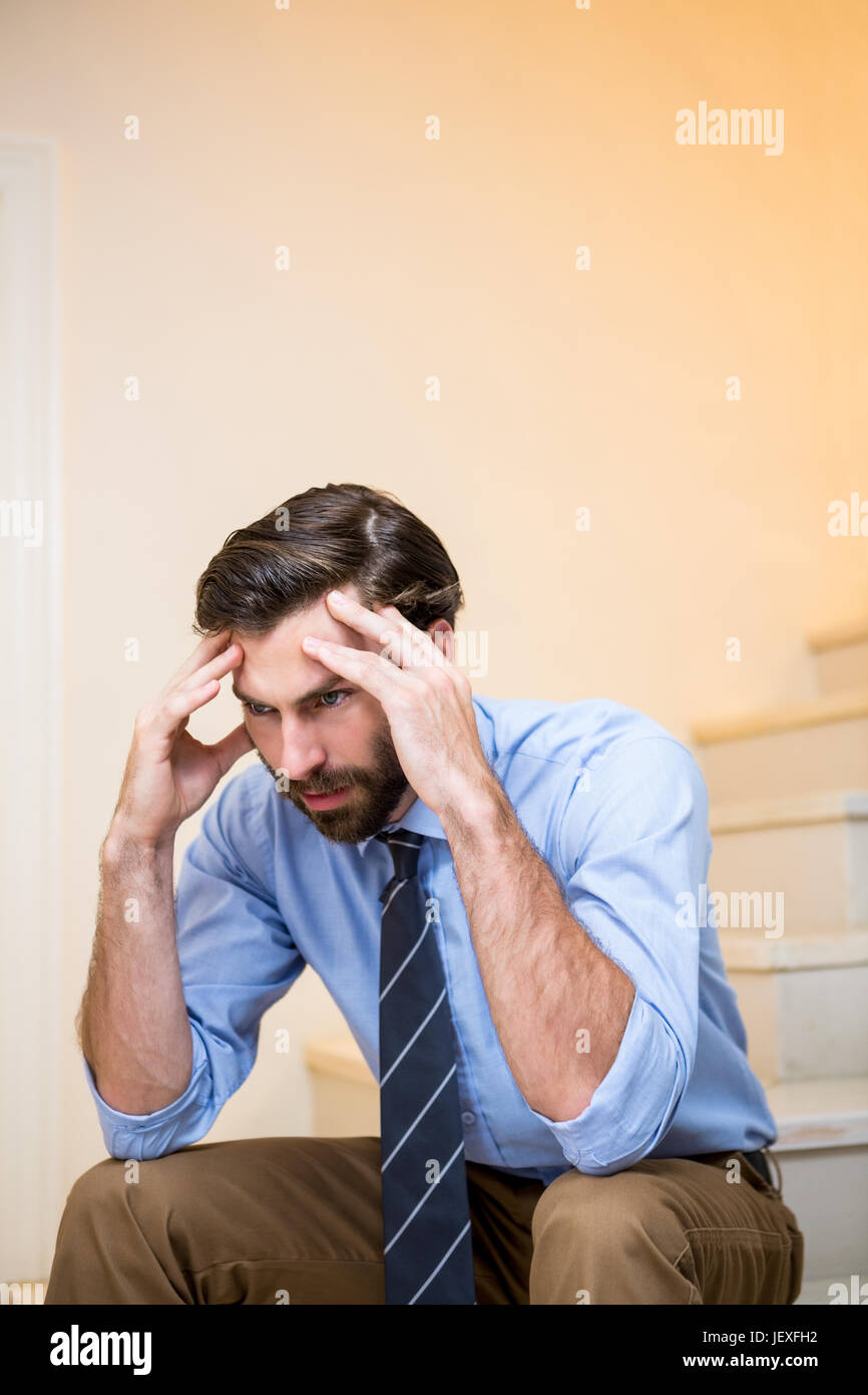 Worried man sitting on stairs Stock Photo - Alamy