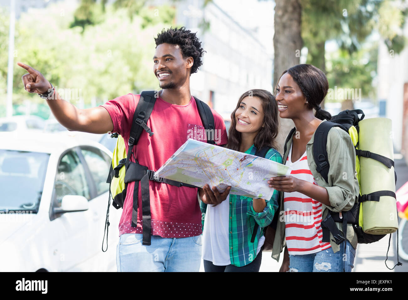 Friends holding map and pointing Stock Photo - Alamy