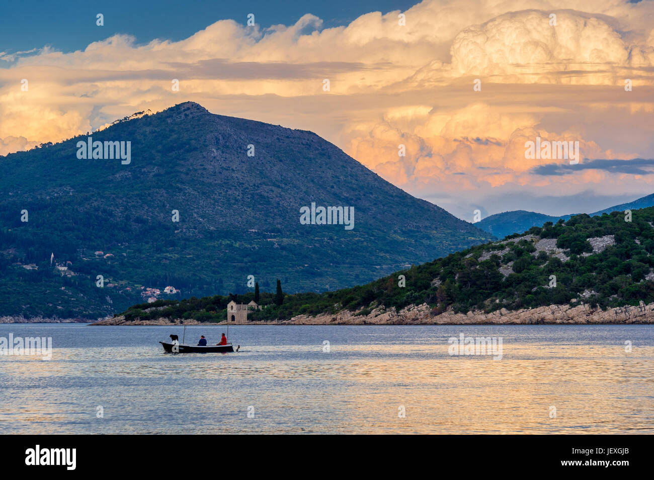 A small fishing boat with a stunning cloud formation at sunset on at ...