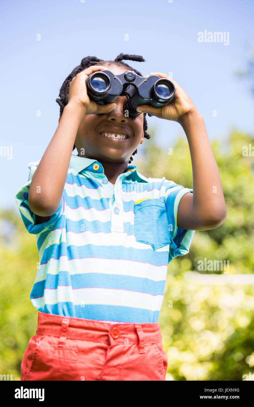 Smiling boy using magnifying glass Stock Photo - Alamy