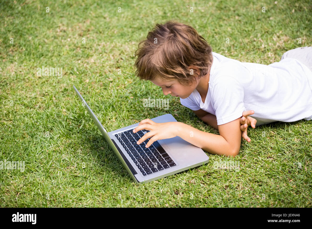 Child lying using a laptop Stock Photo - Alamy