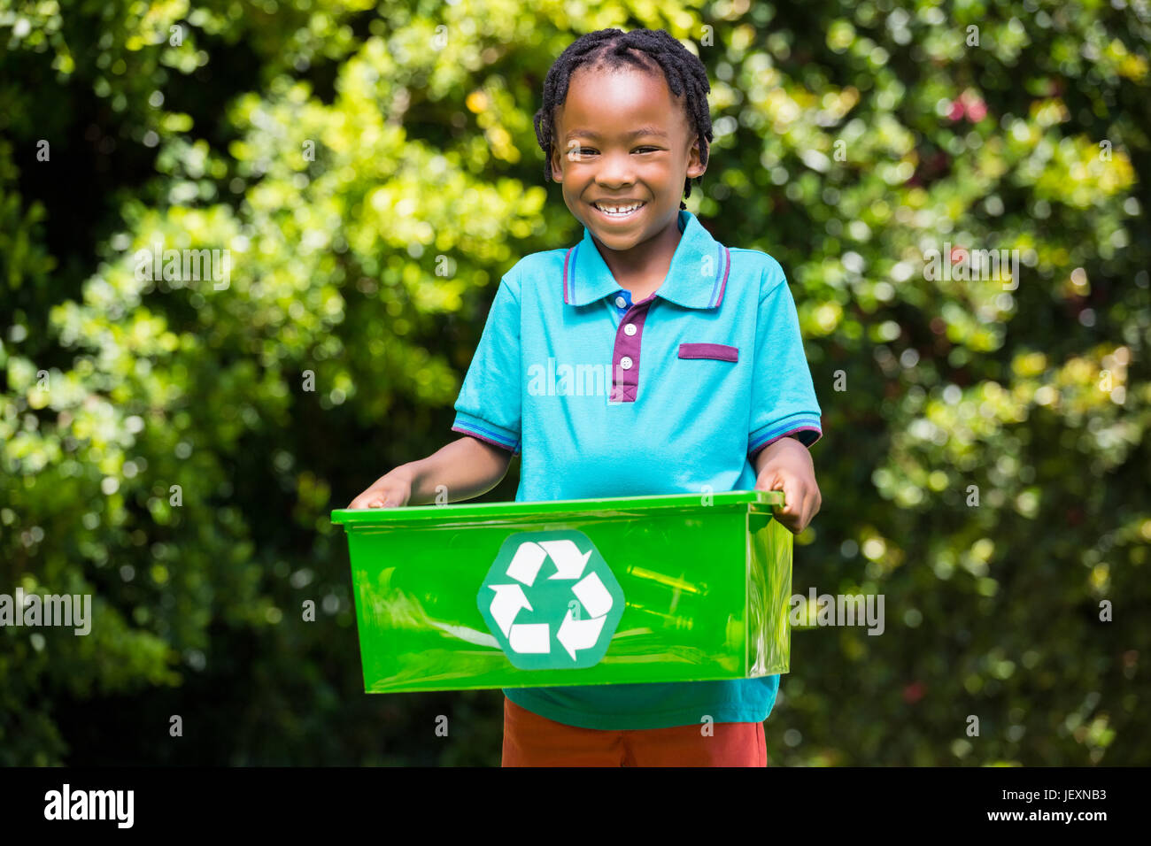 Smiling boy holding a recycling box Stock Photo - Alamy