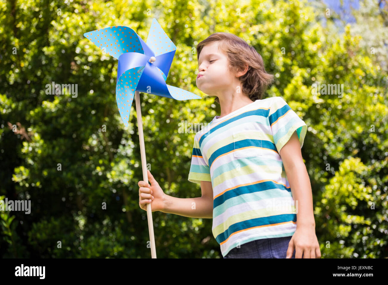 A little boy is blowing on pinwheel Stock Photo - Alamy