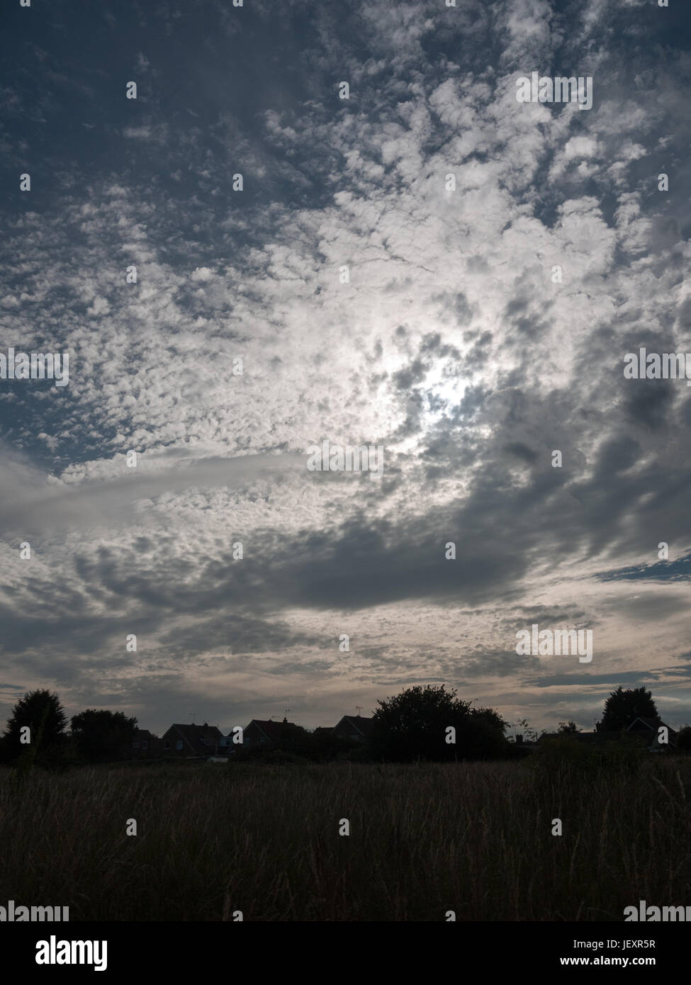 dramatic grey moody and very cloudy messy sky over a field outside ...