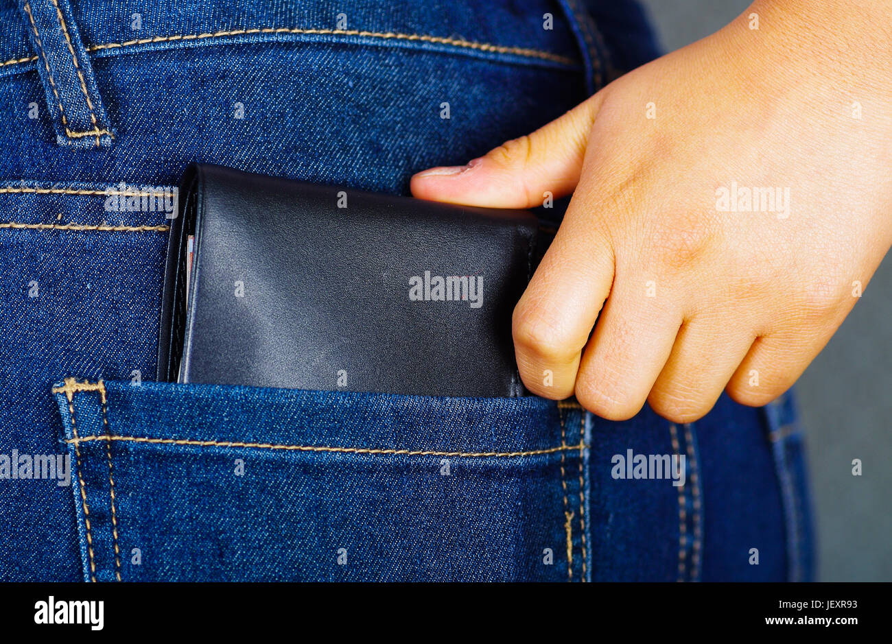 Woman hand putting a black wallet inside of jeans back pocket Stock ...
