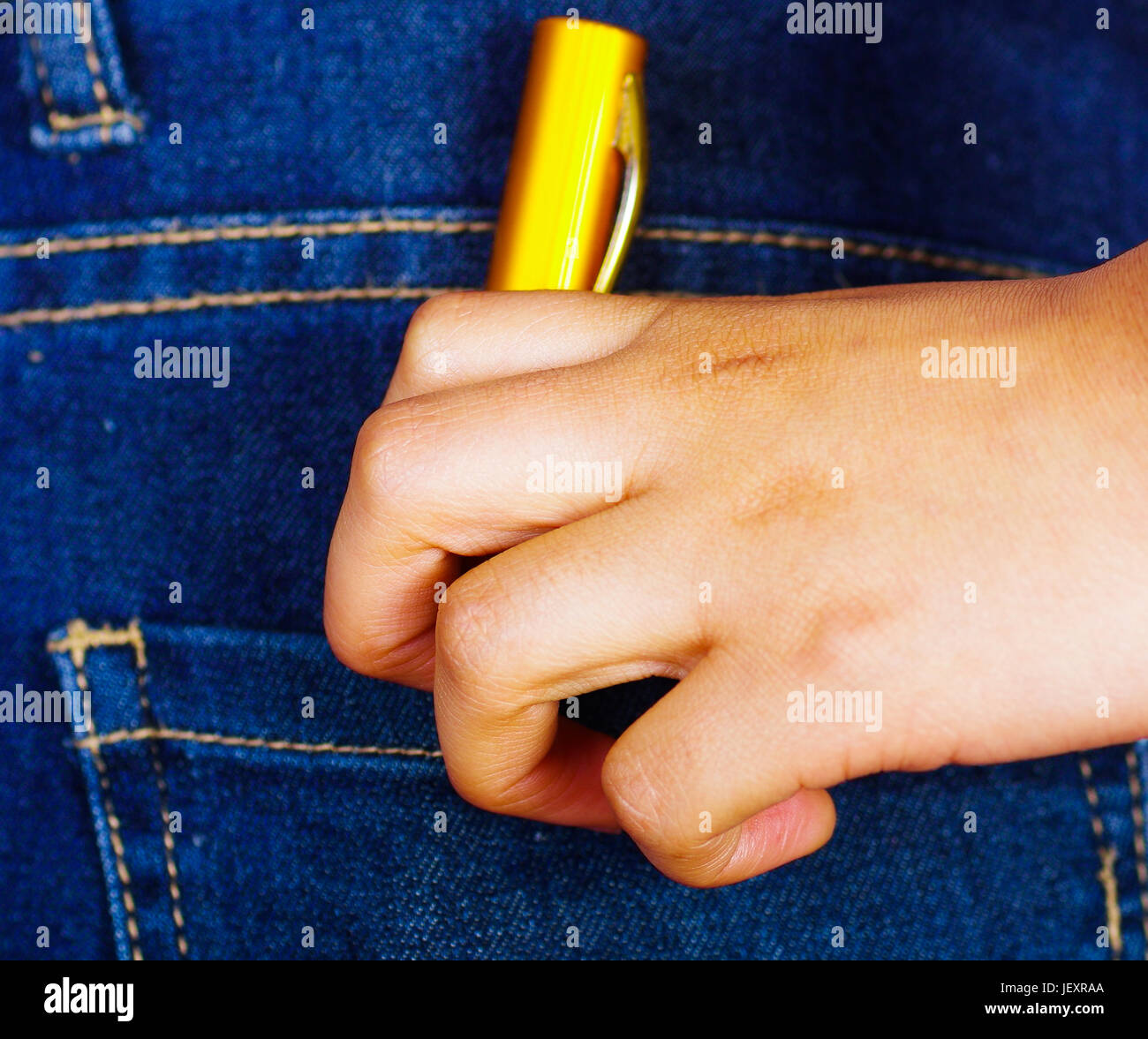 Woman hand holding a golden pen inside of jeans back pocket Stock Photo ...