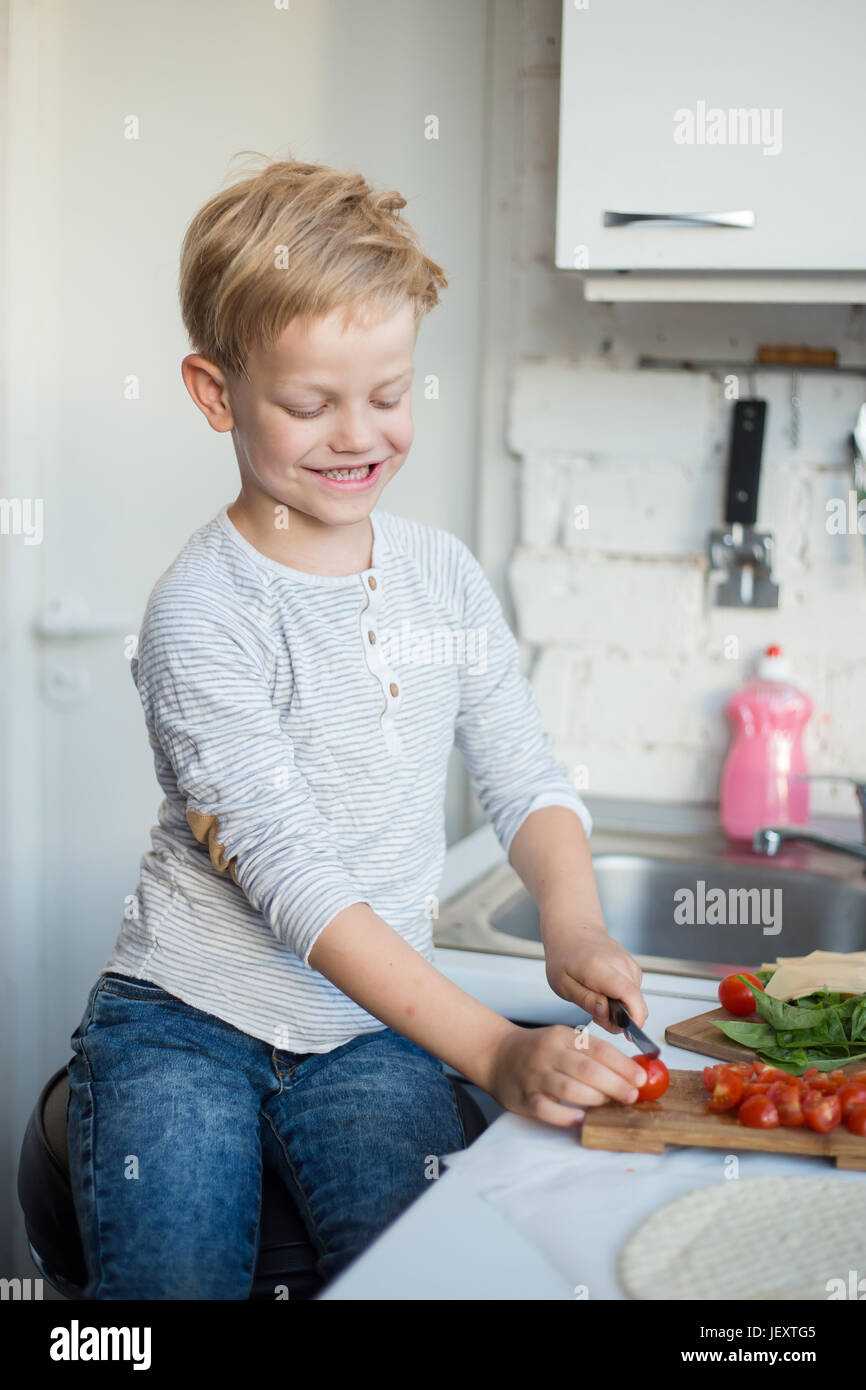 Kid chef is cooking in the kitchen at home. Healthy food Stock Photo ...