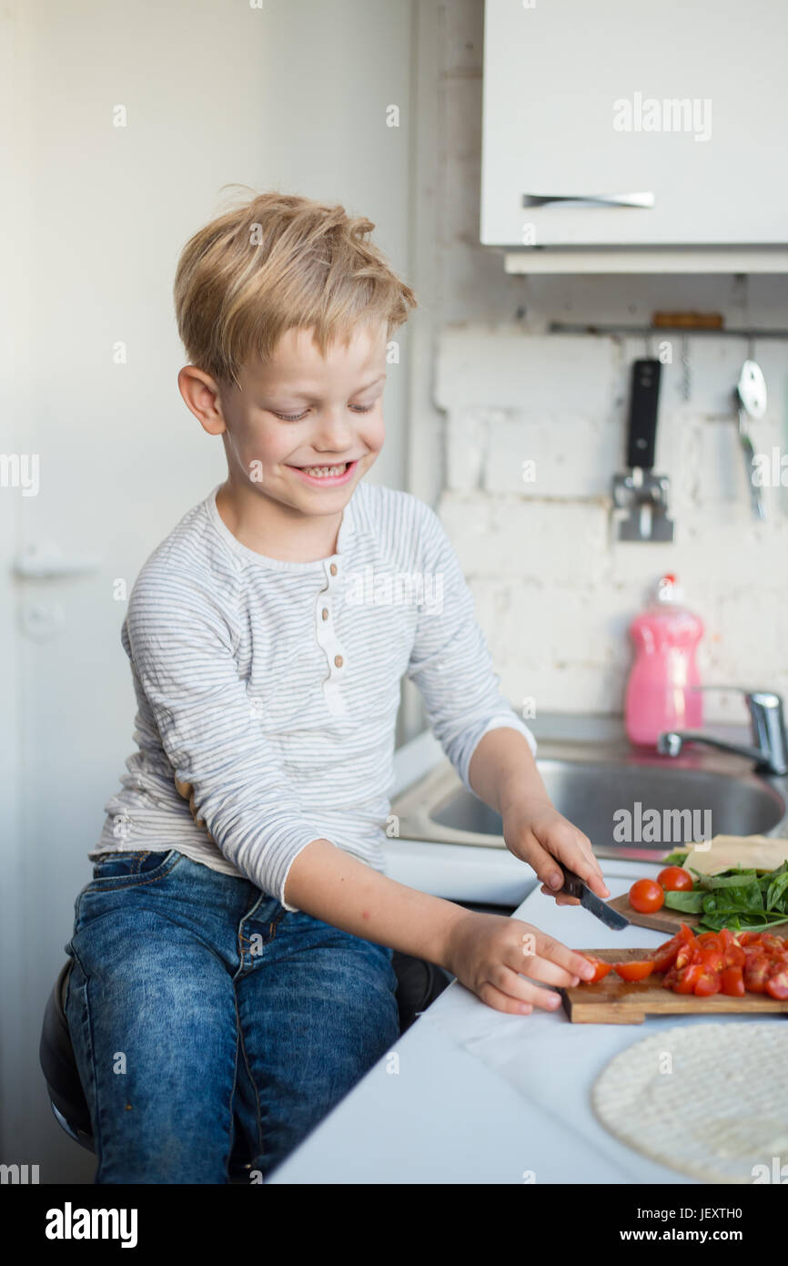 Kid chef is cooking in the kitchen at home. Healthy food Stock Photo ...