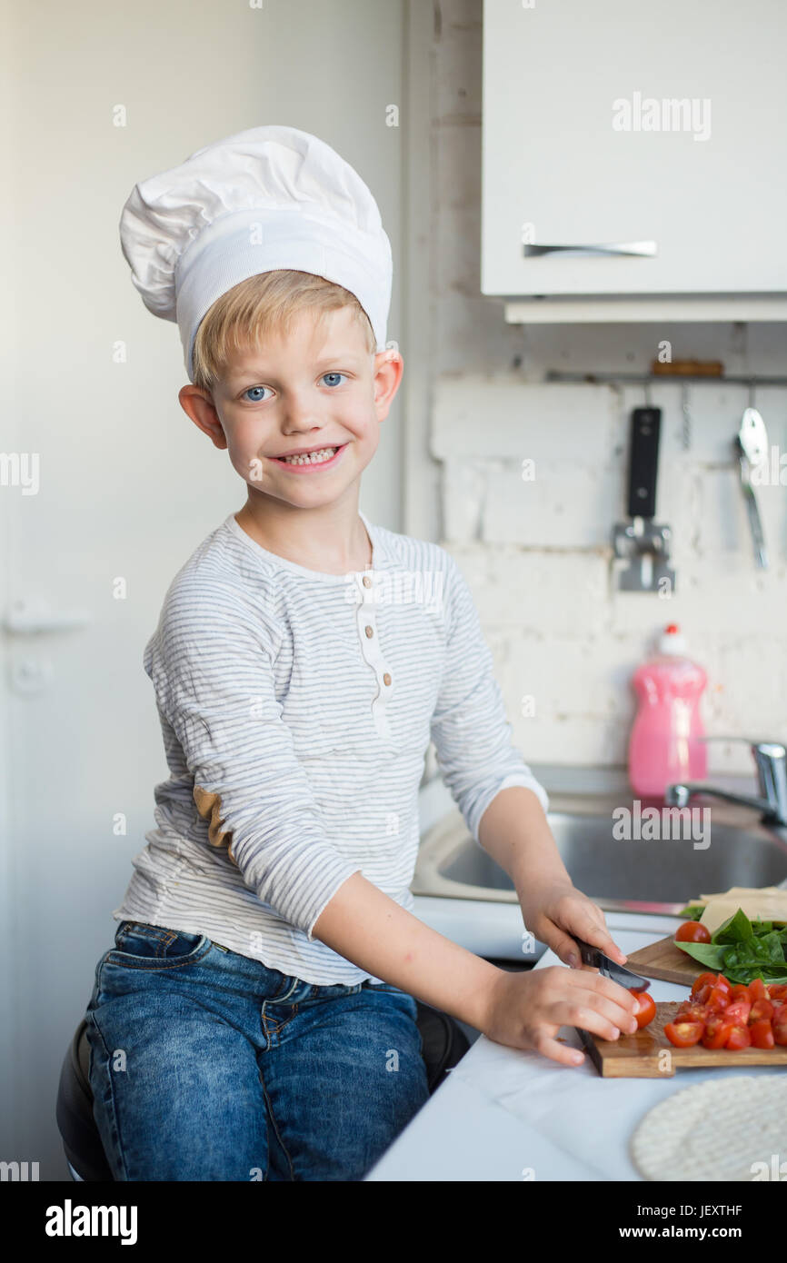 Kid chef is cooking in the kitchen at home. Healthy food Stock Photo ...