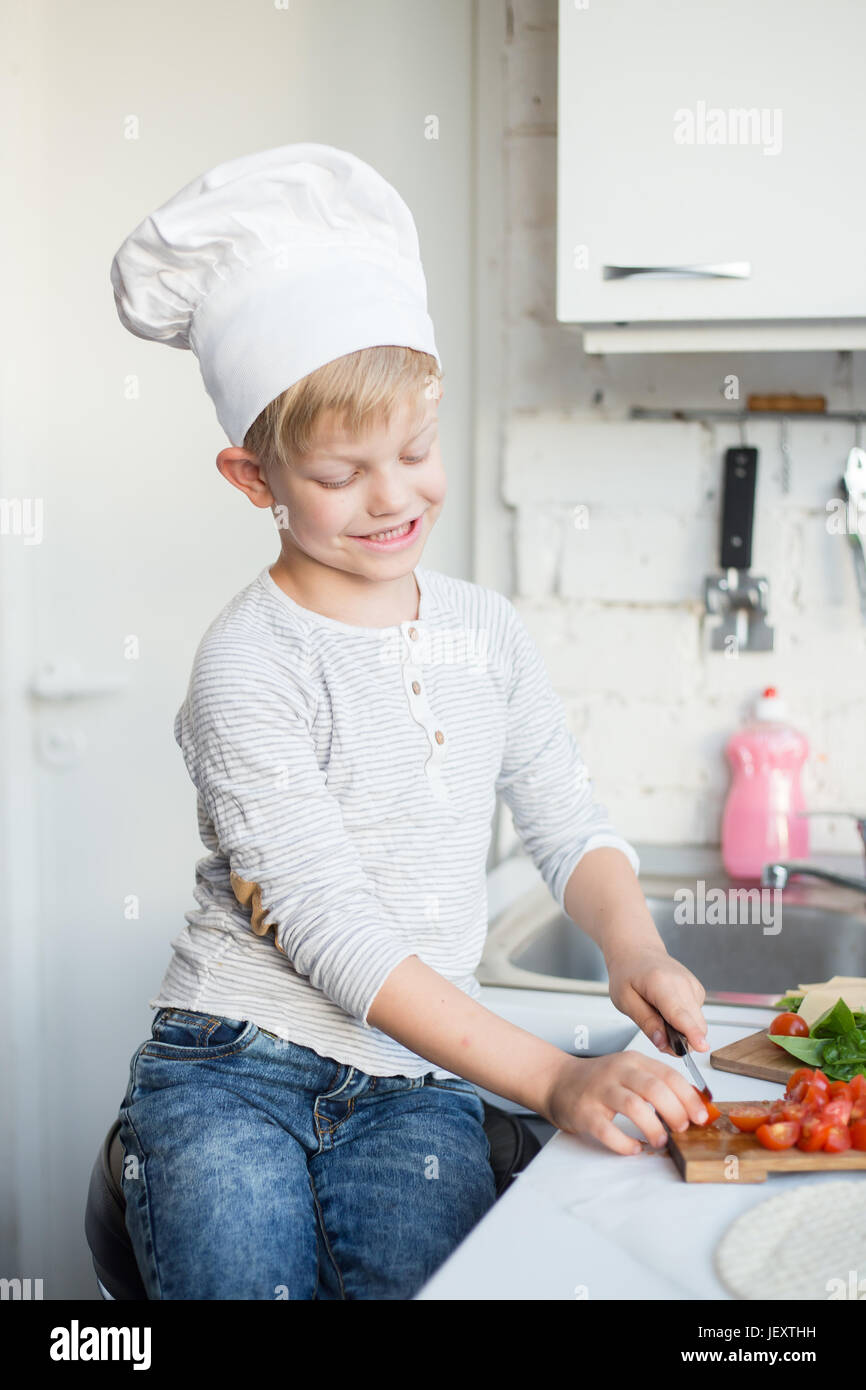Kid chef is cooking in the kitchen at home. Healthy food Stock Photo ...