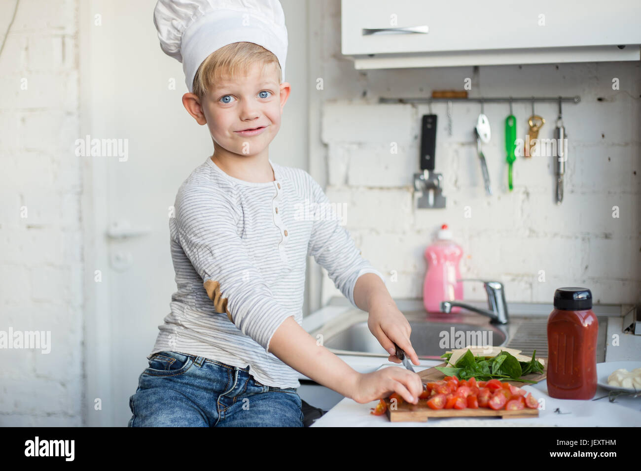 Kid chef is cooking in the kitchen at home. Healthy food Stock Photo ...