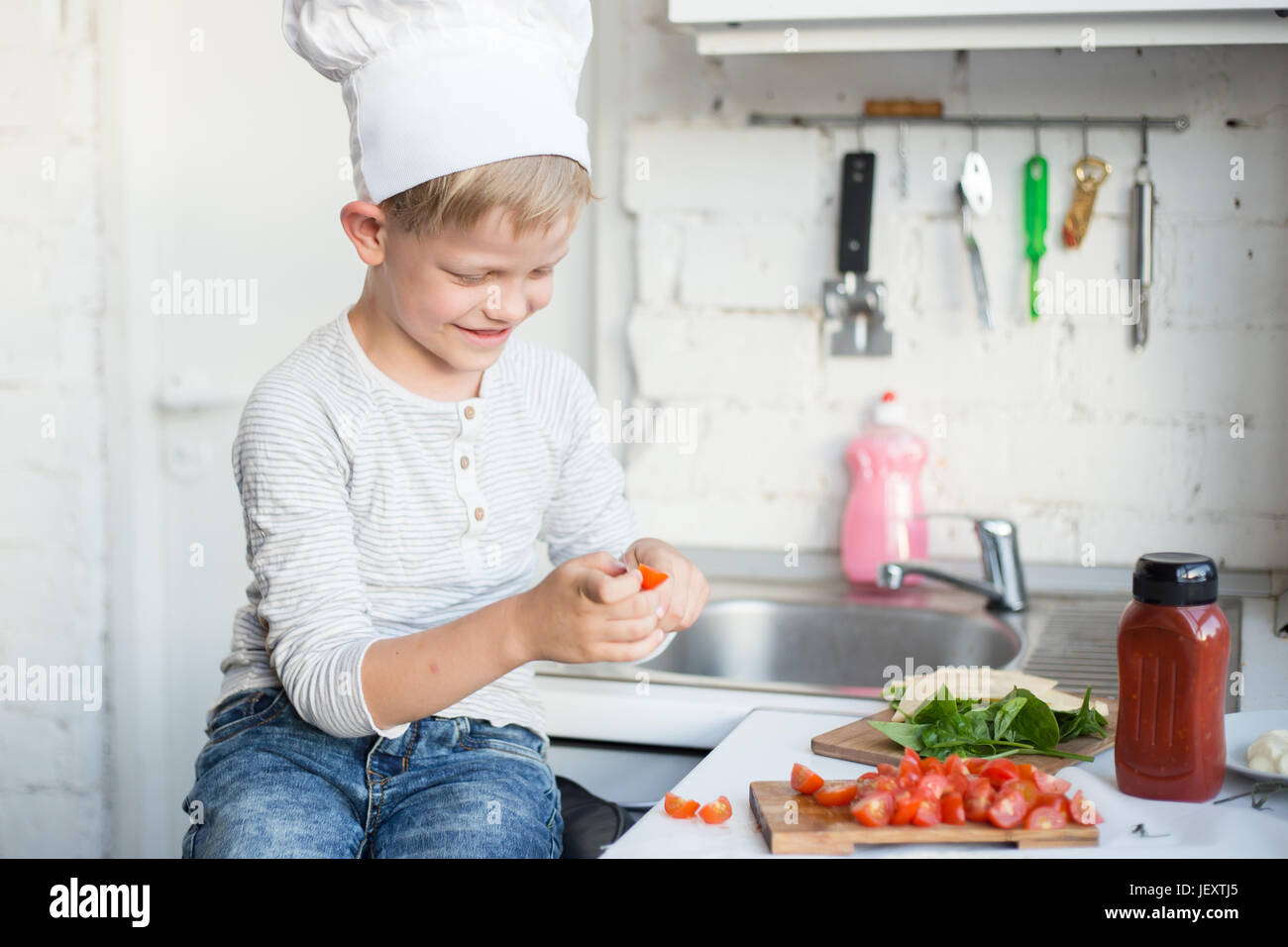 Kid chef is cooking in the kitchen at home. Healthy food Stock Photo ...