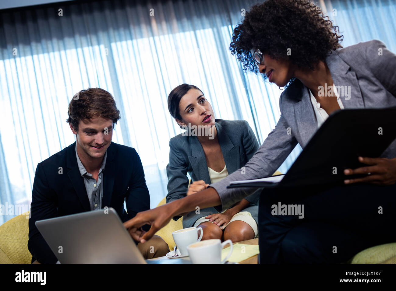 Coworkers having meeting around table Stock Photo - Alamy