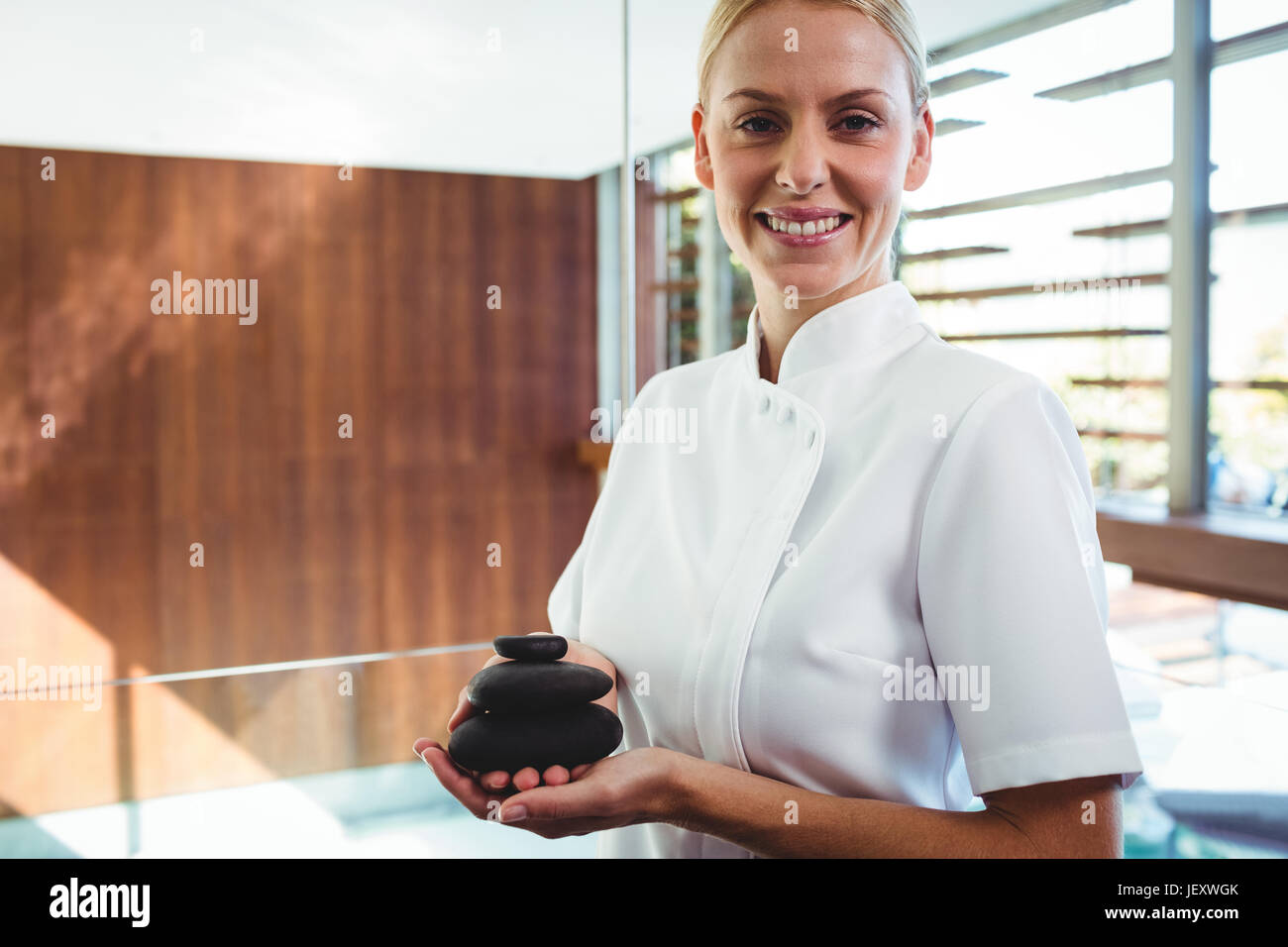 Masseuse holding stones massage Stock Photo - Alamy