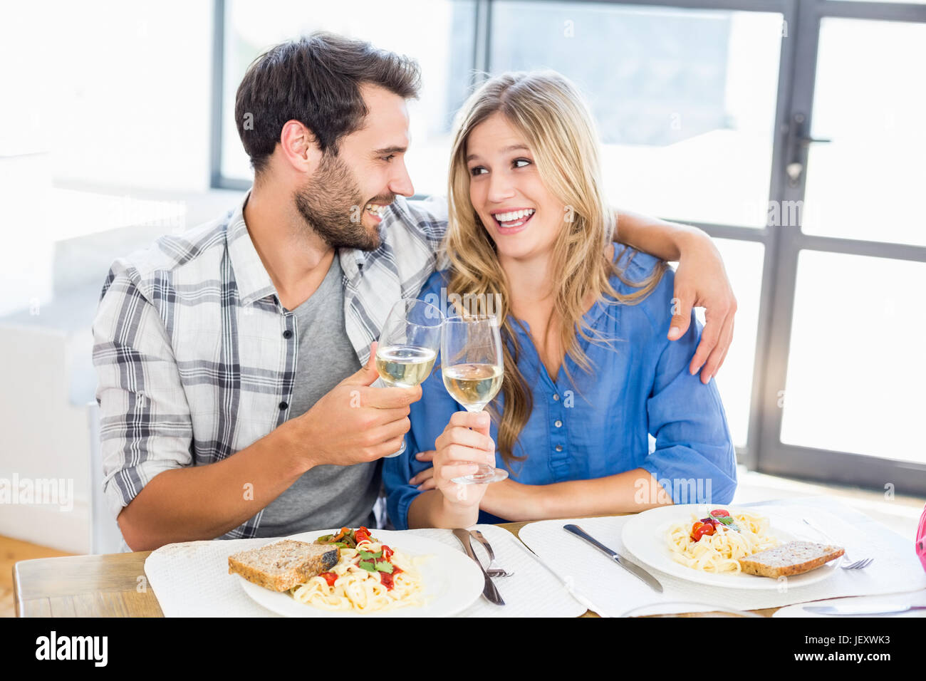 Young couple toasting wine glasses Stock Photo - Alamy
