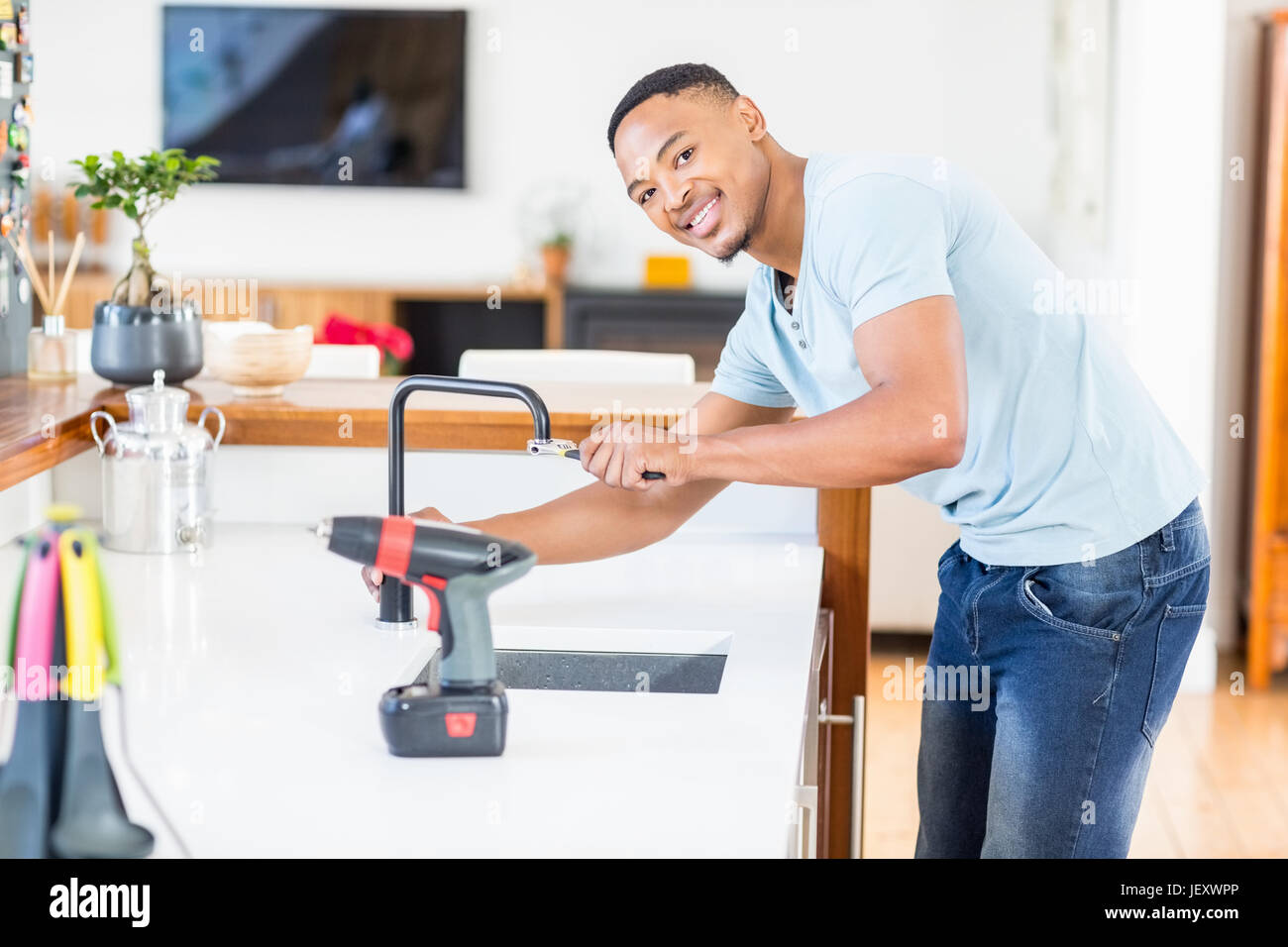 Man tightening tap with a wrench Stock Photo - Alamy